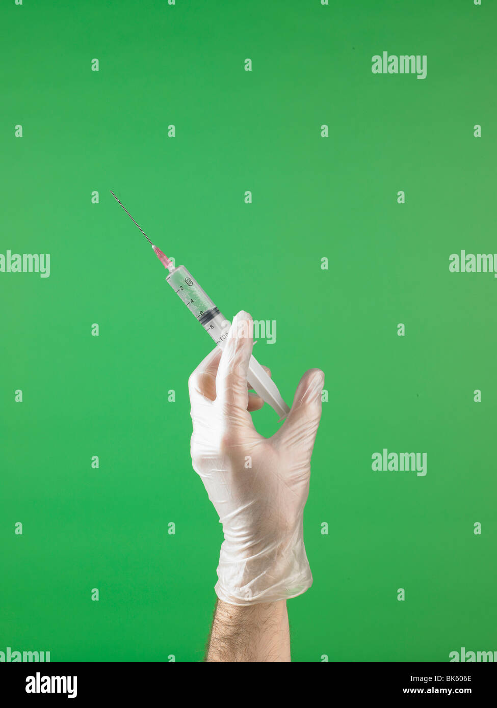 Medical gloved hand with syringe and needle Stock Photo - Alamy