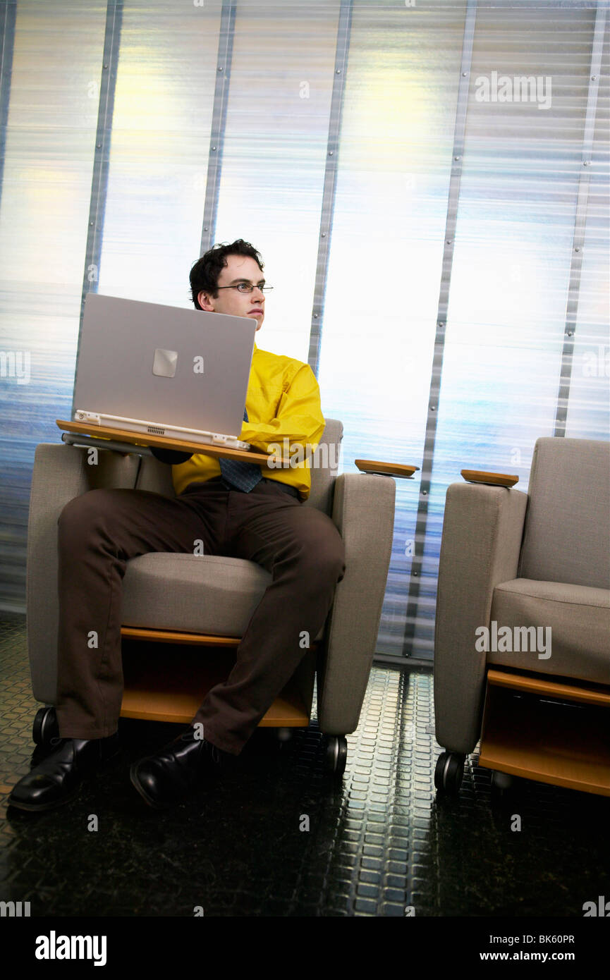 Businessman sitting in an armchair with a laptop Stock Photo - Alamy