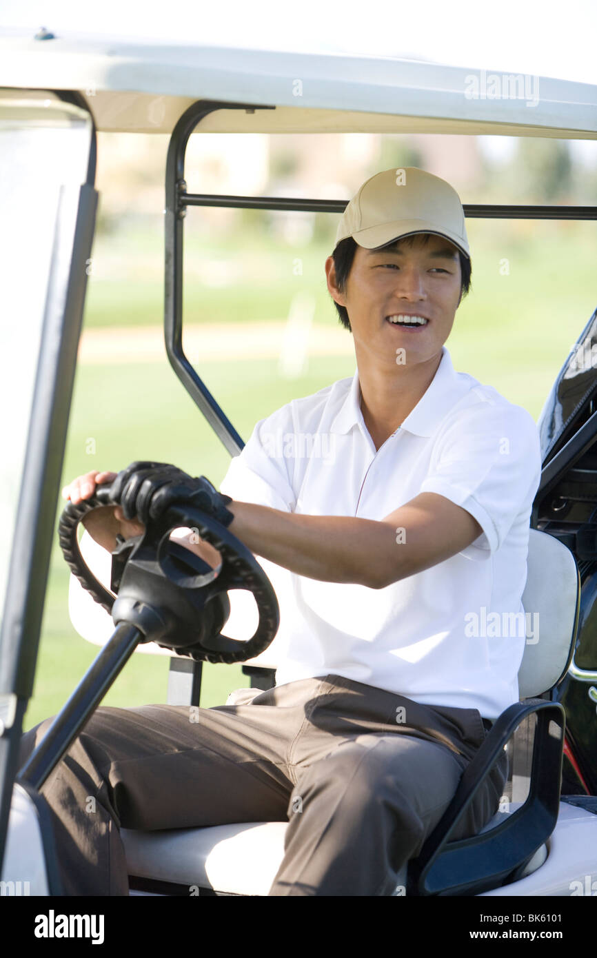 Man driving golf cart Stock Photo - Alamy