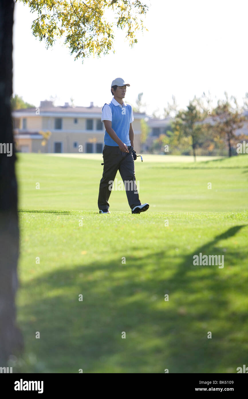 Man walking on golf course Stock Photo - Alamy