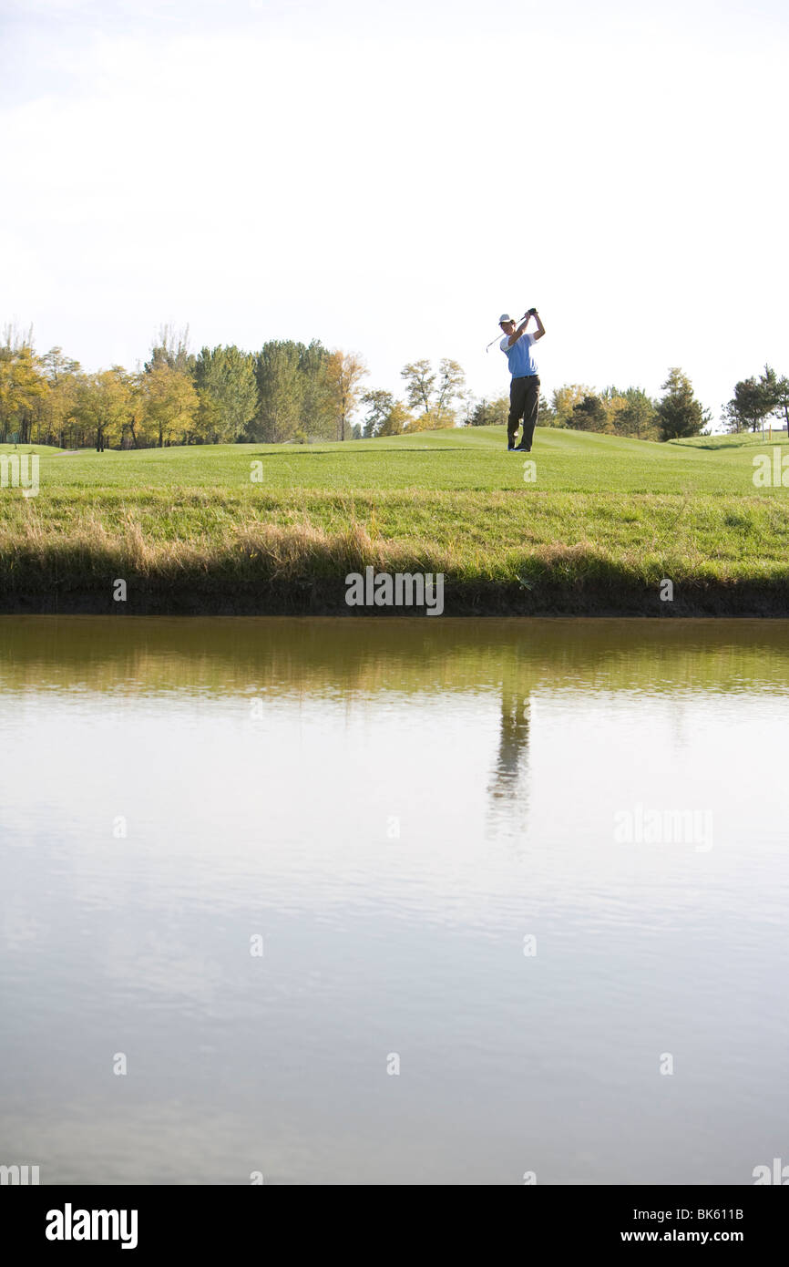 Man swinging golf club on golf course Stock Photo - Alamy