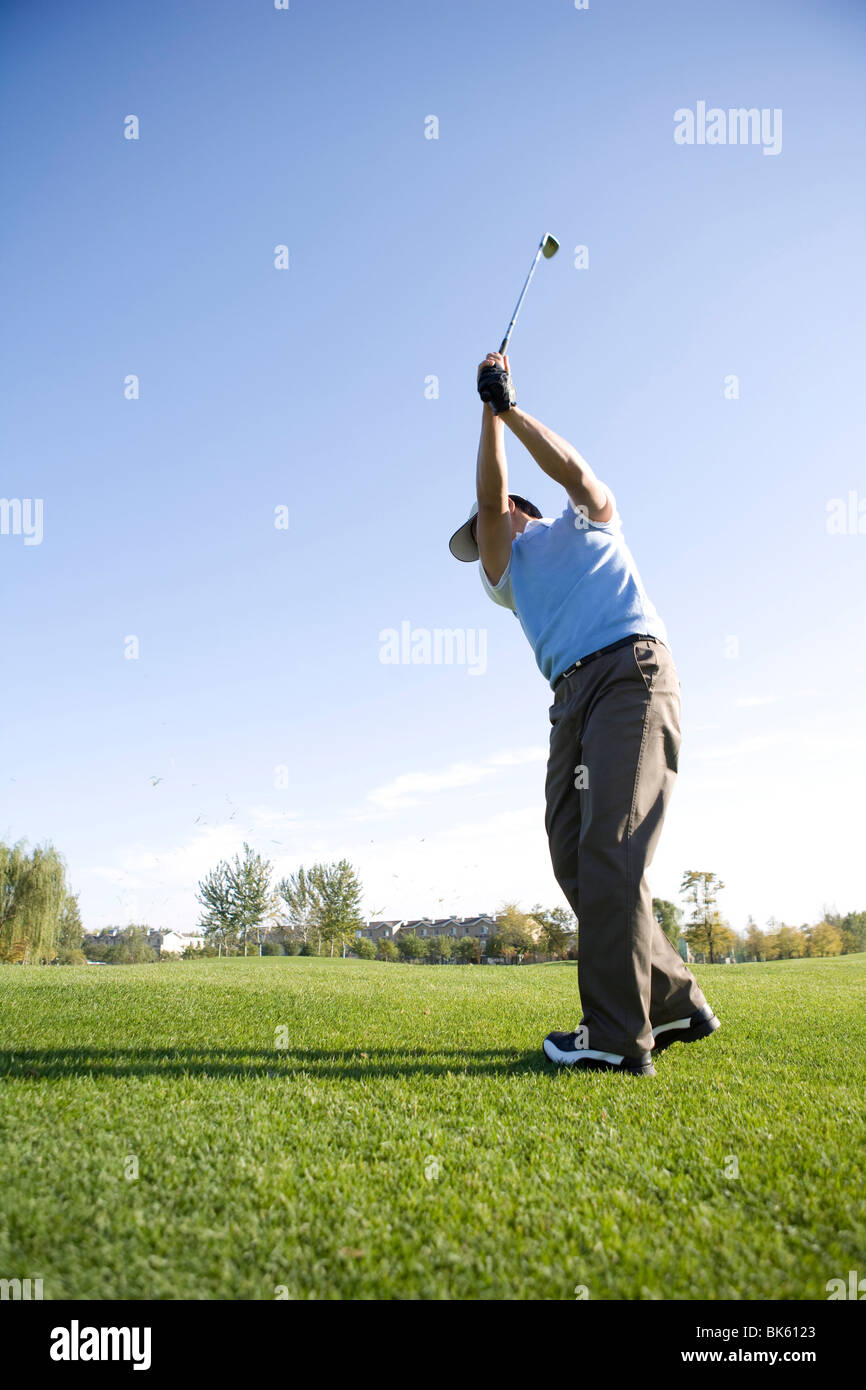 Man swinging golf club on golf course Stock Photo - Alamy