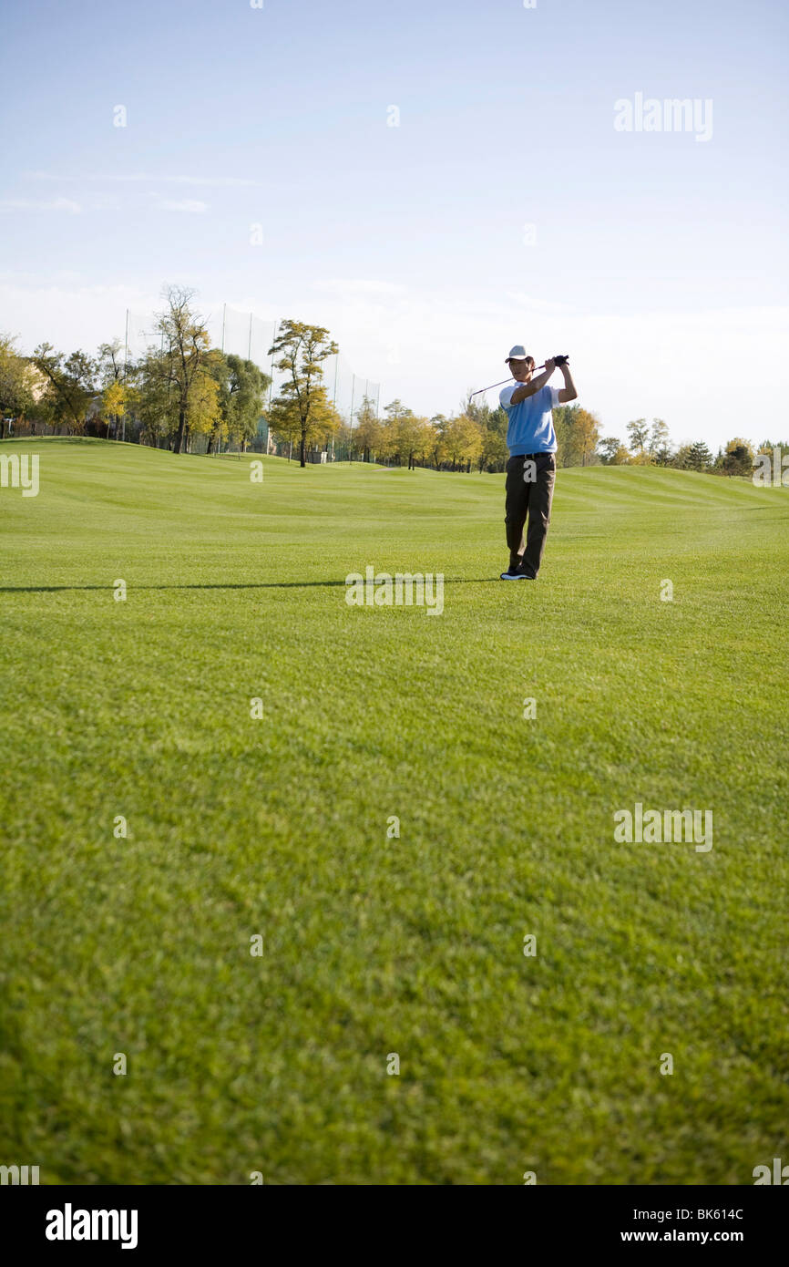 Man swinging golf club on golf course Stock Photo - Alamy