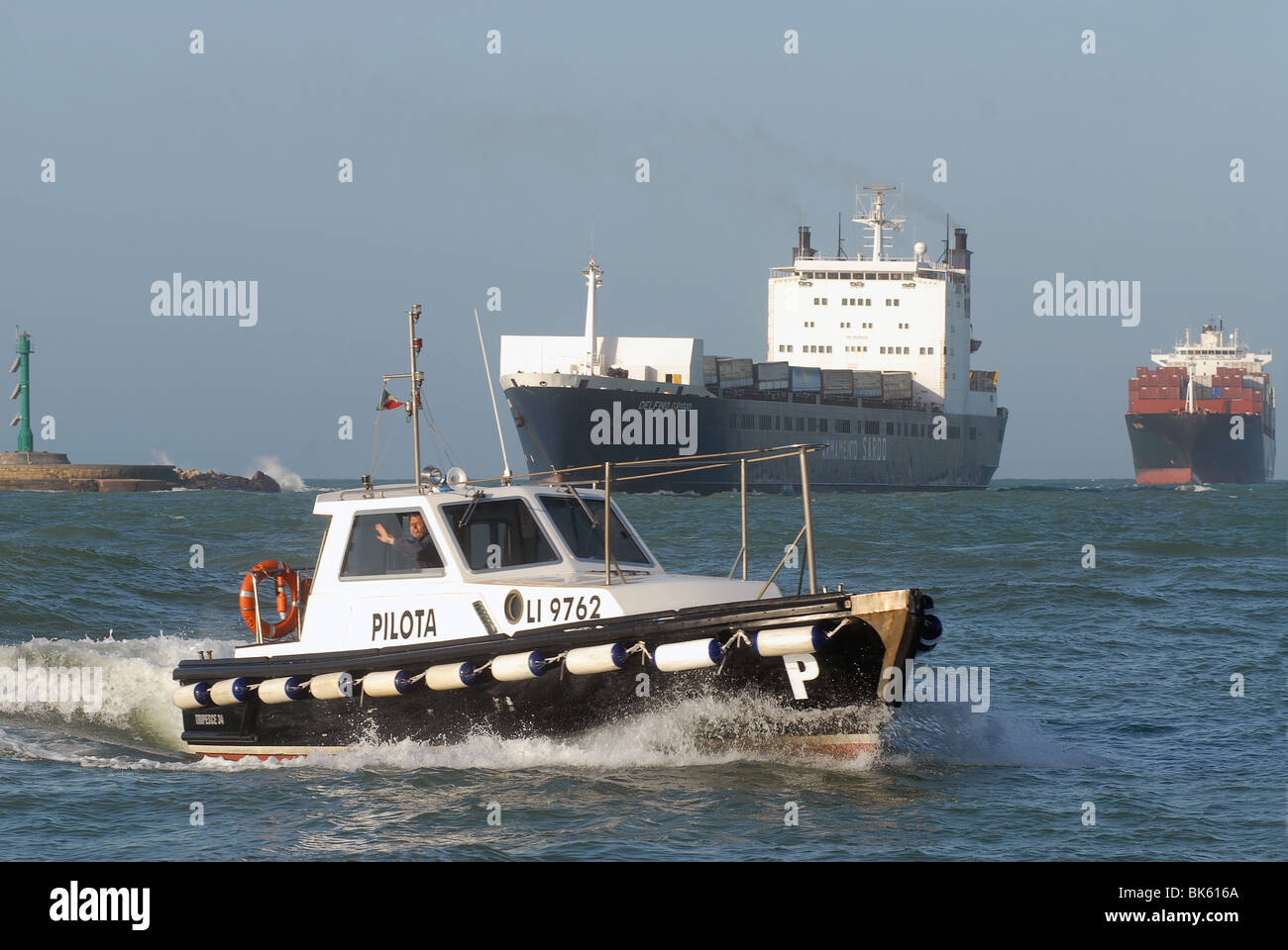cargo ships manoeuvring in the port of Livorno (Italy), pilot boat ...