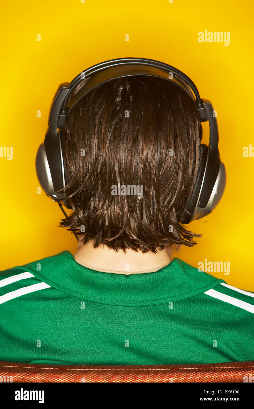 Rear view of a young man listening to music Stock Photo - Alamy