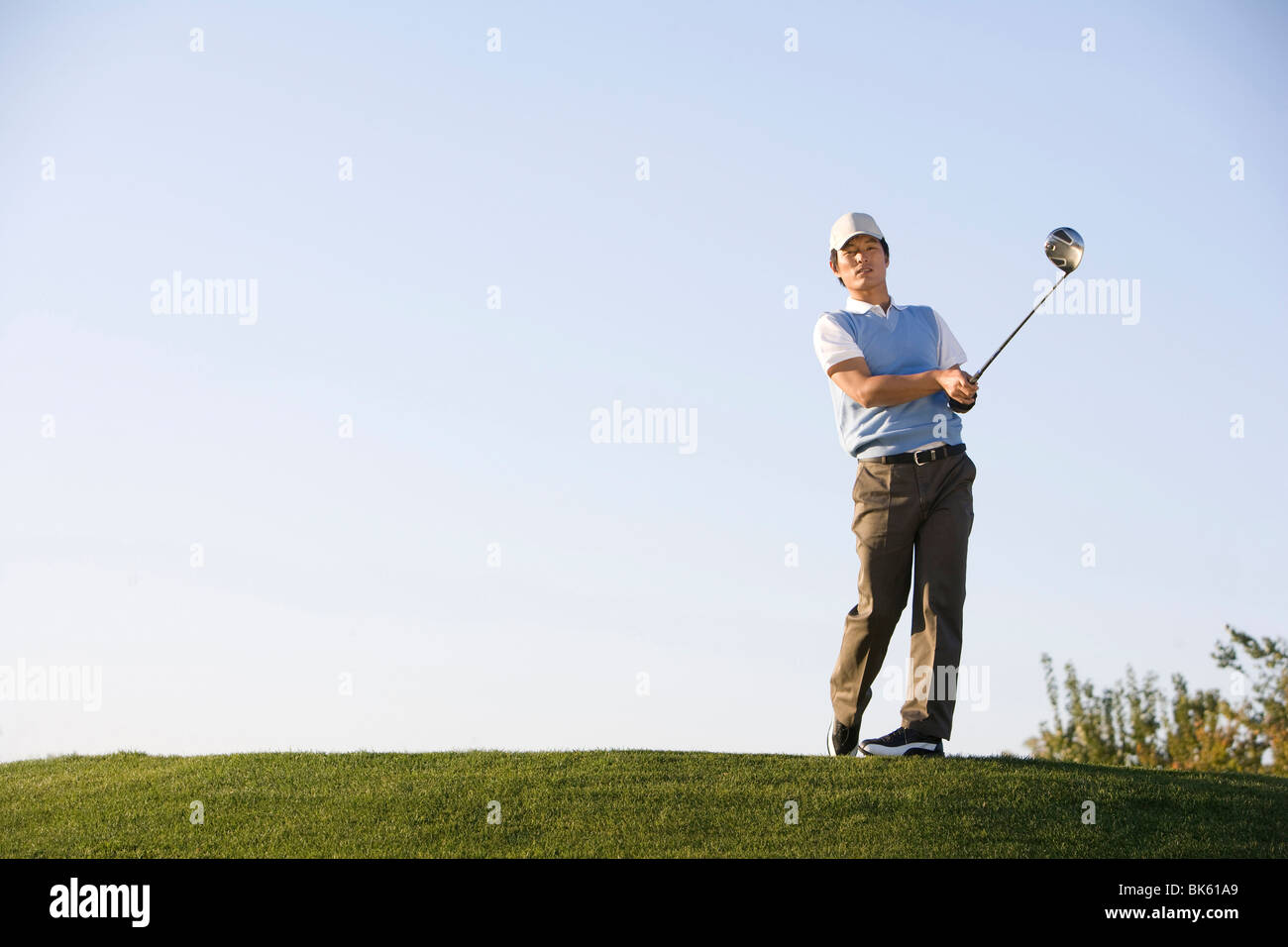 Golfer teeing off on the course Stock Photo - Alamy