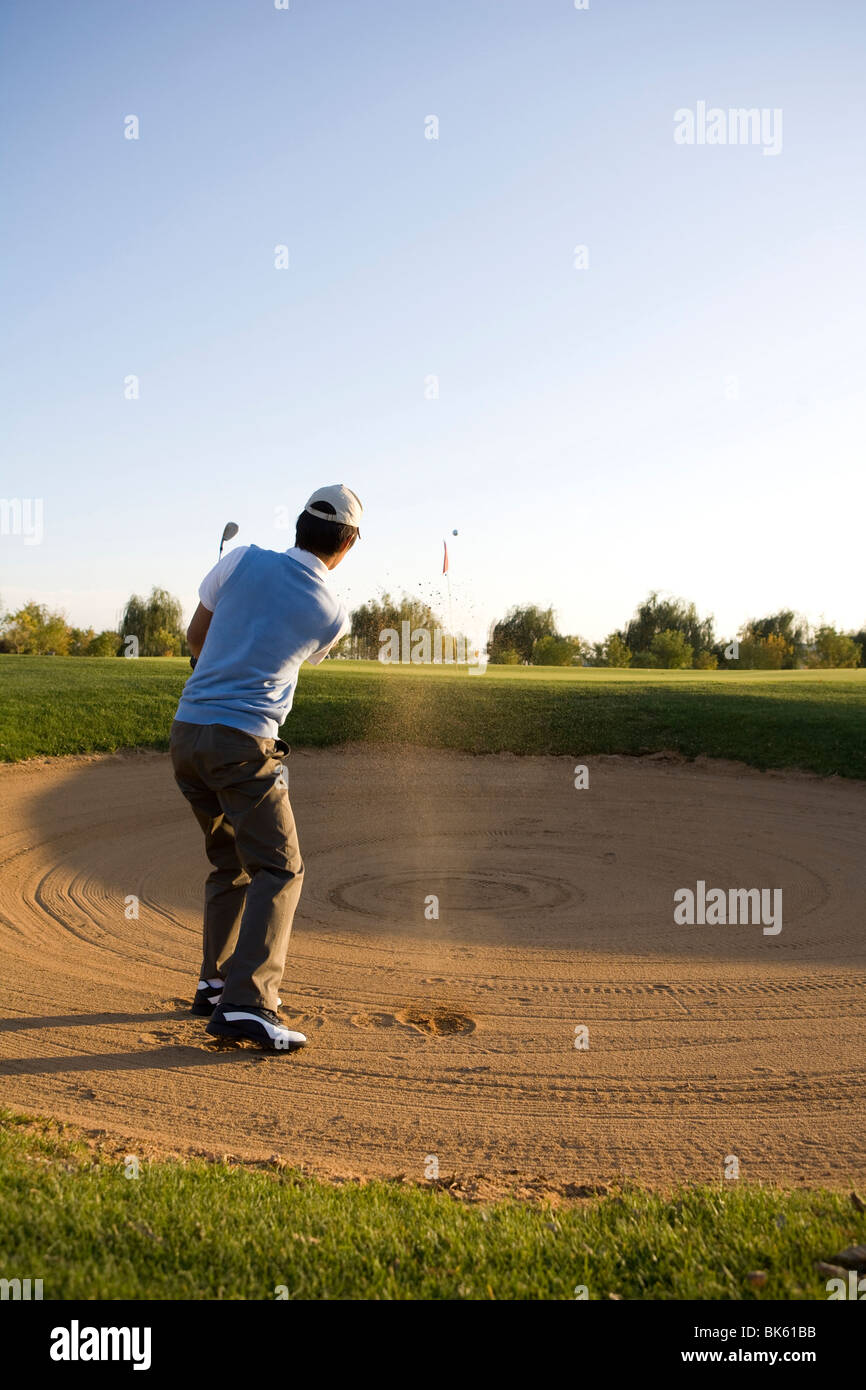 Glofer swinging in sand trap Stock Photo - Alamy