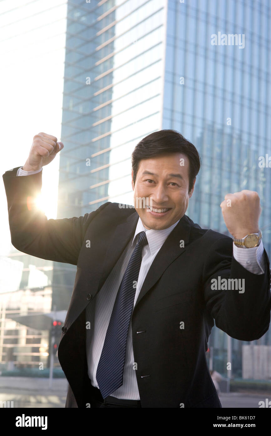 Businessman celebrating in front of office building Stock Photo - Alamy