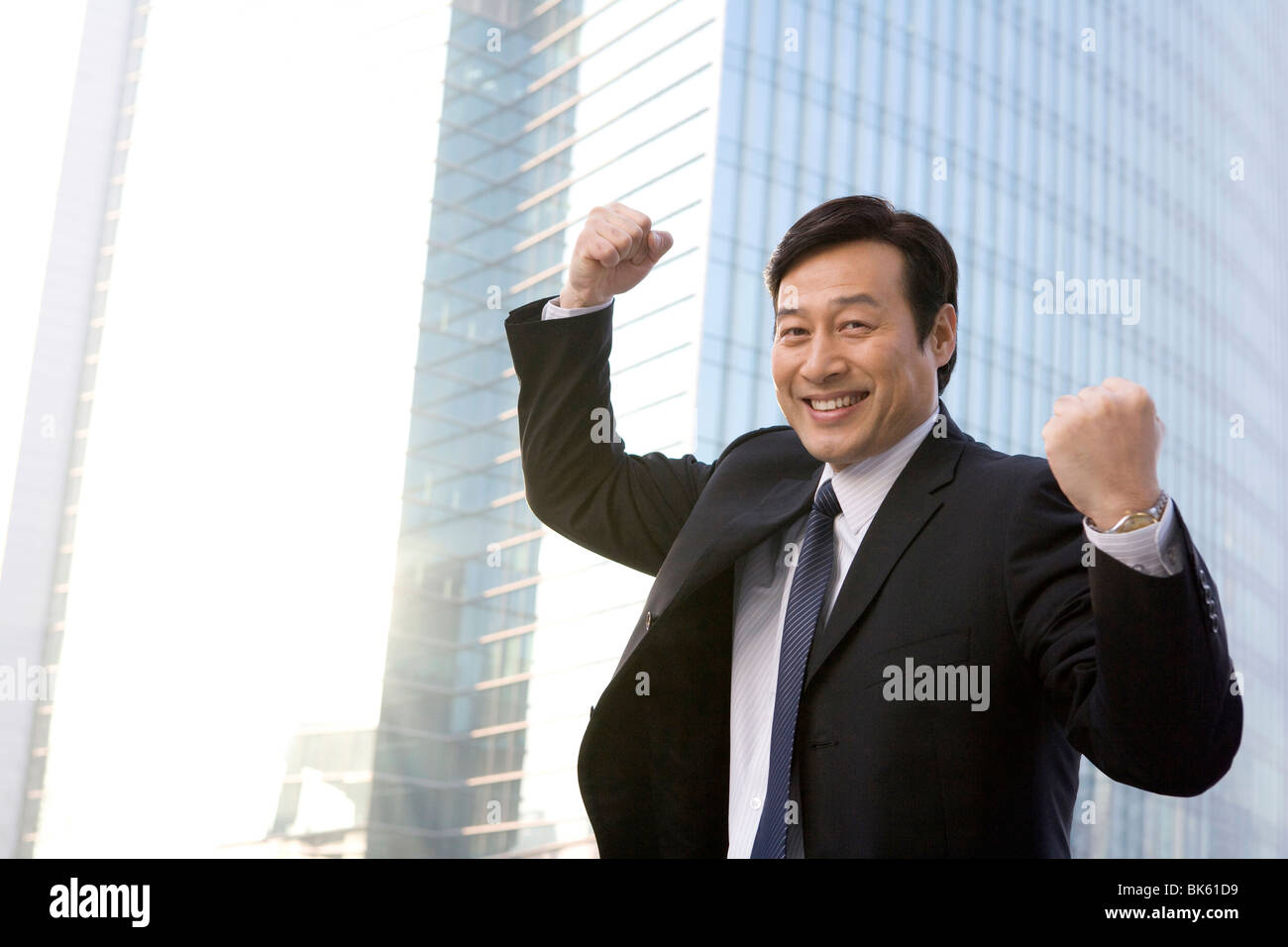Businessman celebrating in front of office building Stock Photo - Alamy