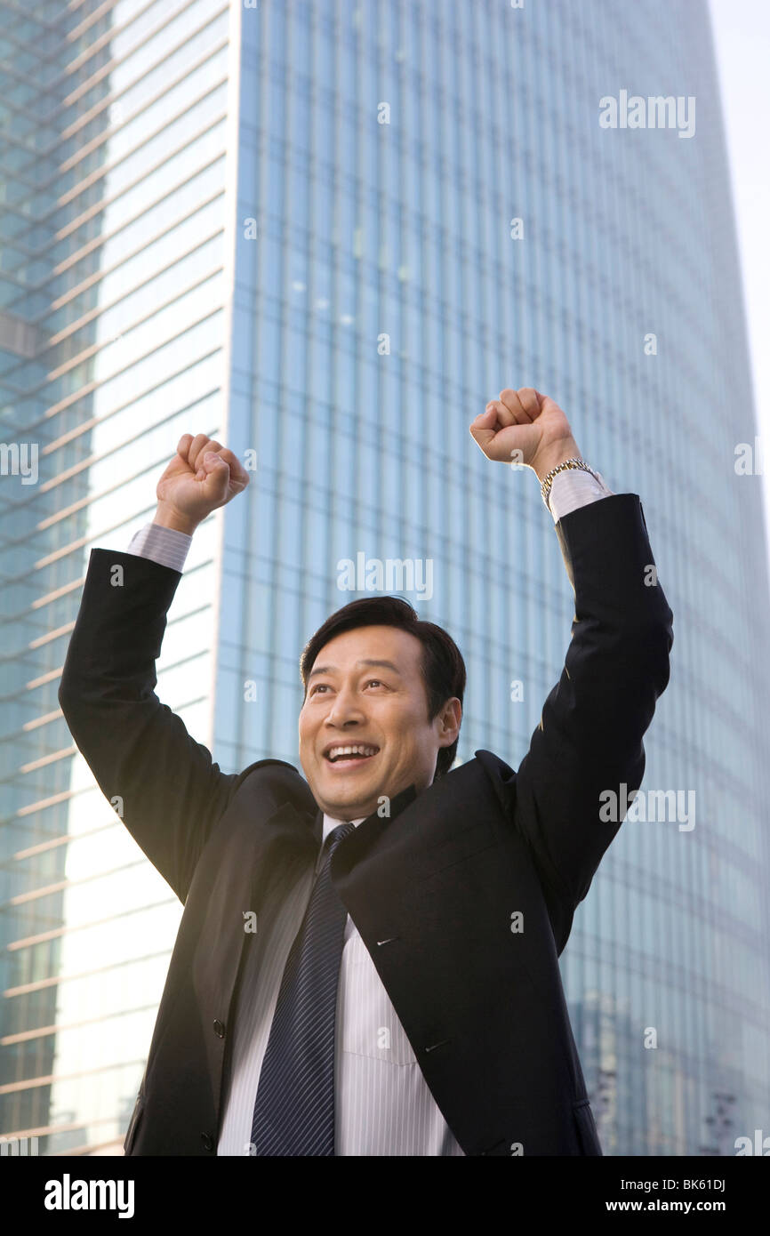 Businessman celebrating in front of office building Stock Photo - Alamy