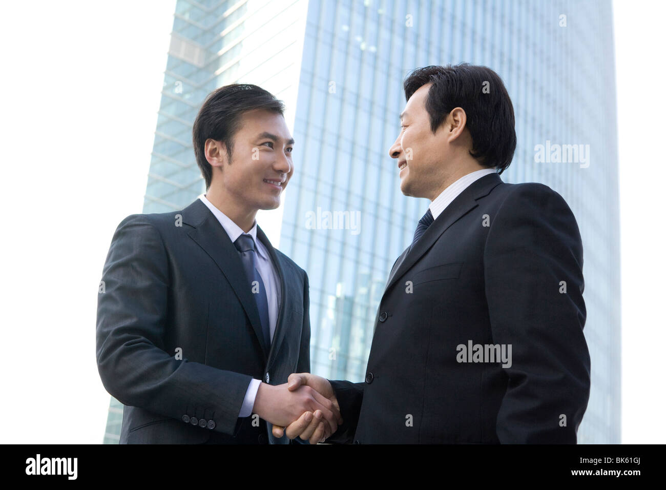 Standing shaking hands looking away strength communication hi-res stock ...