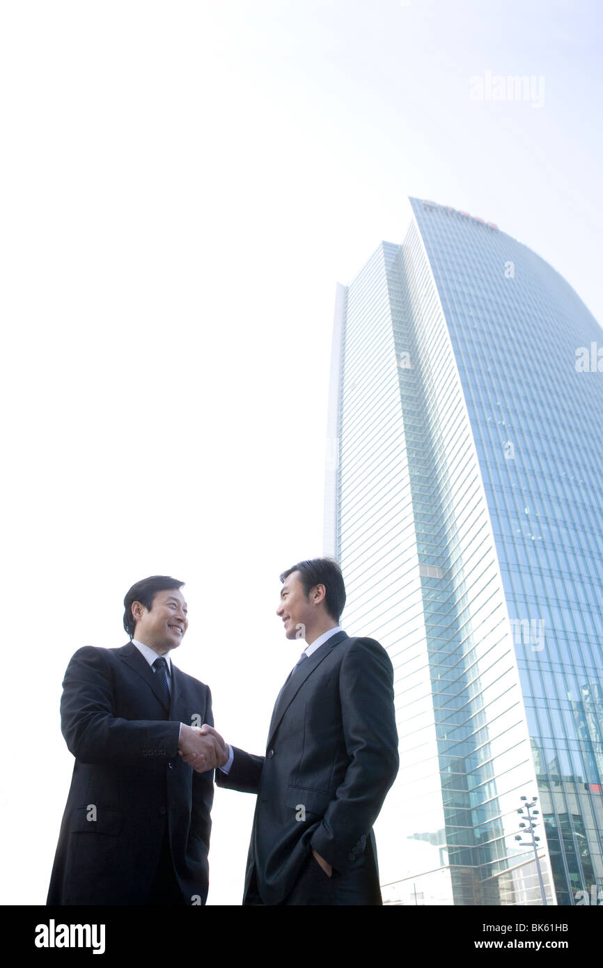 Standing shaking hands looking away strength communication hi-res stock ...