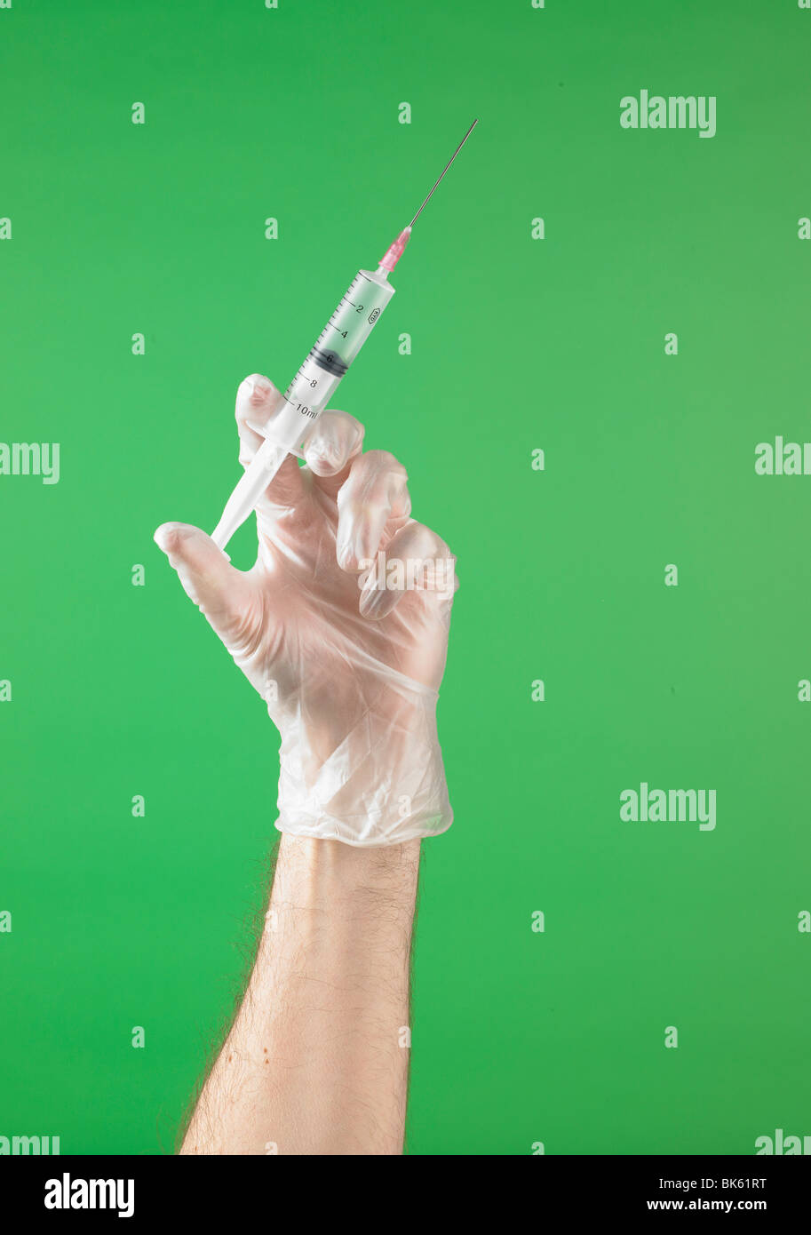 Medical gloved hand with syringe and needle and arm Stock Photo - Alamy