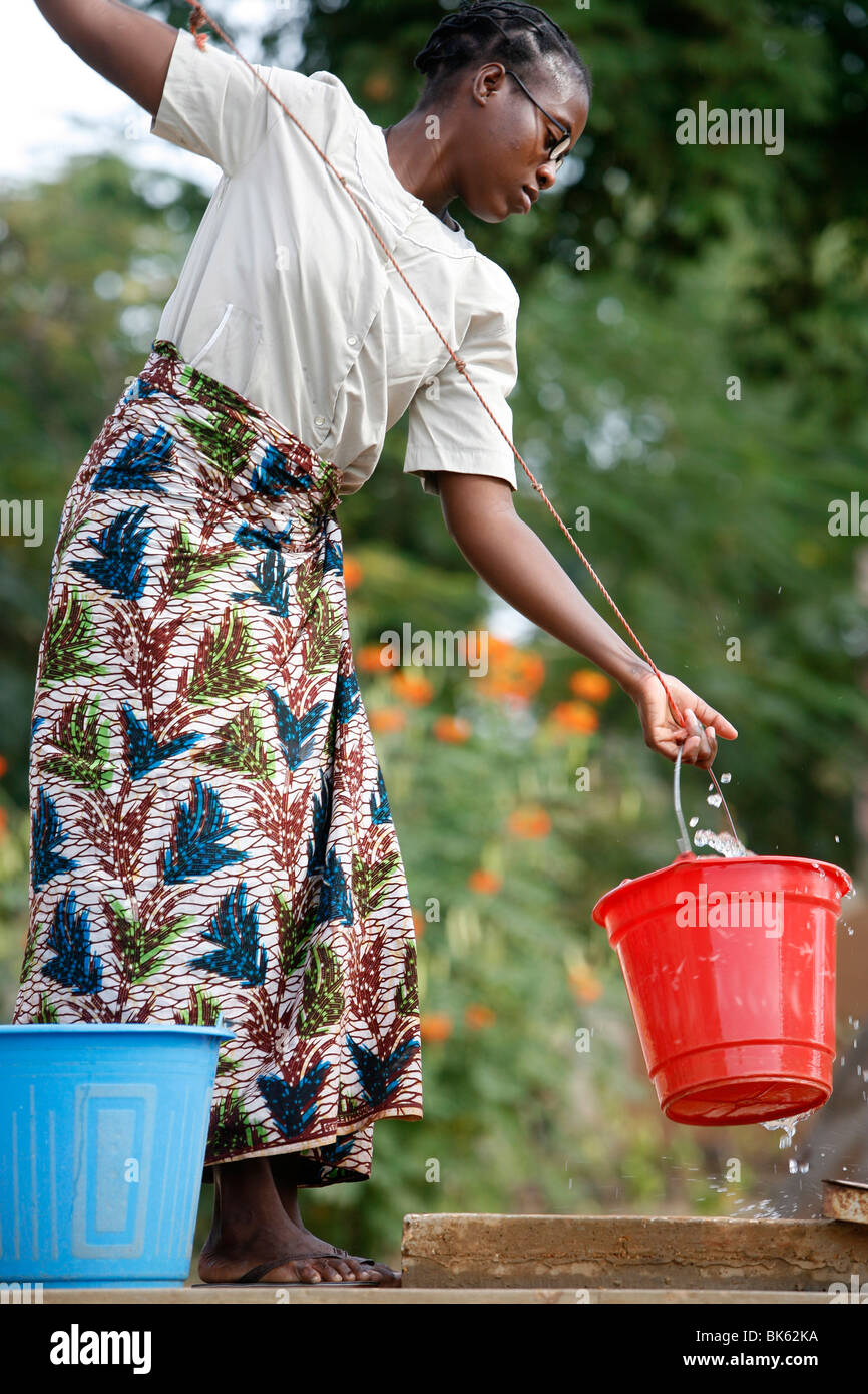 Woman getting water well bucket hi-res stock photography and images - Alamy