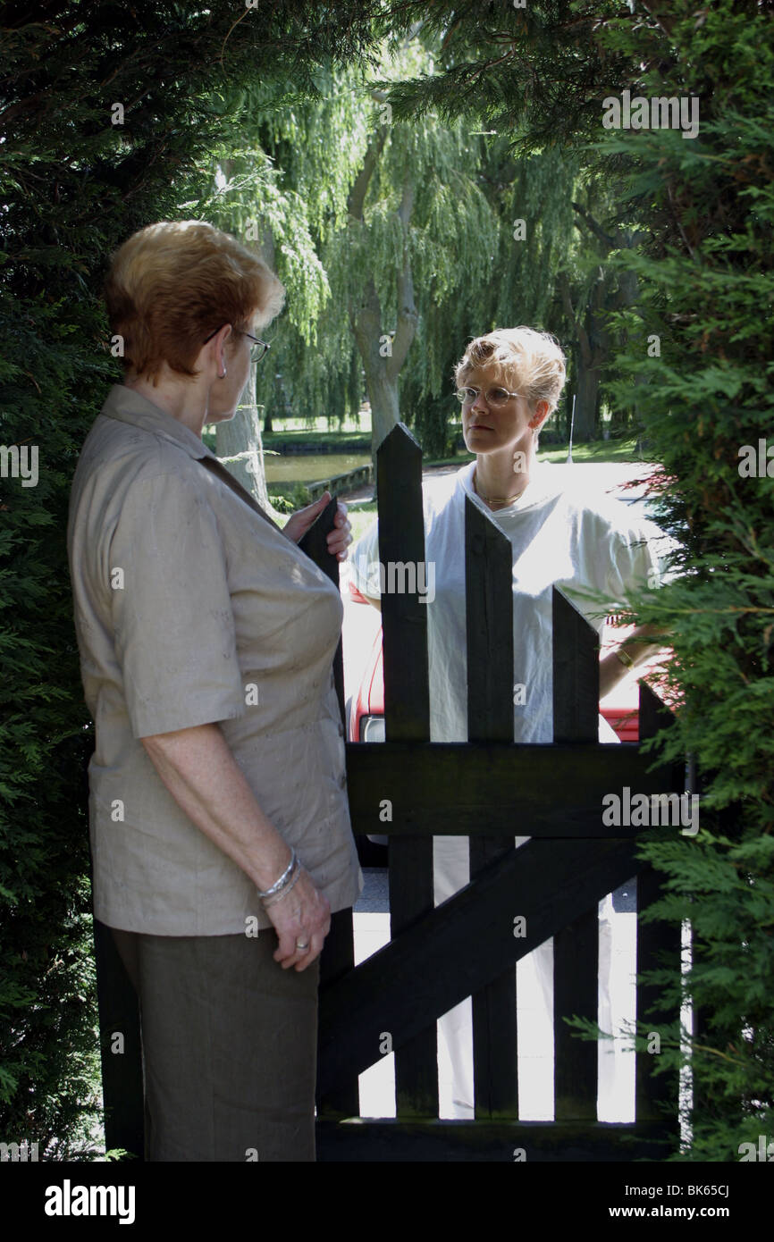 Mature women talking over fence hi-res stock photography and images - Alamy