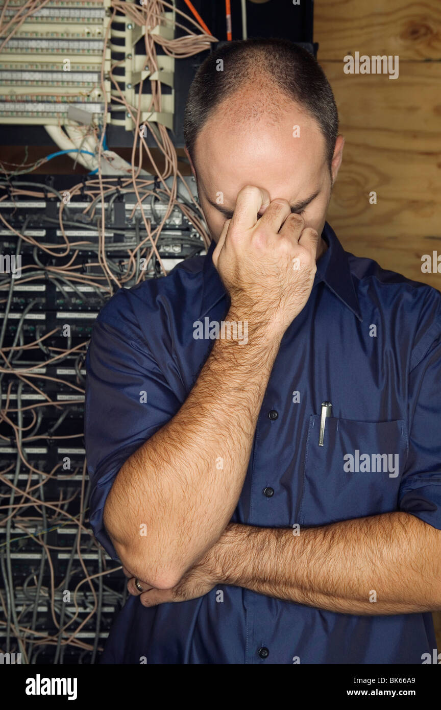 Technician thinking in a server room Stock Photo - Alamy