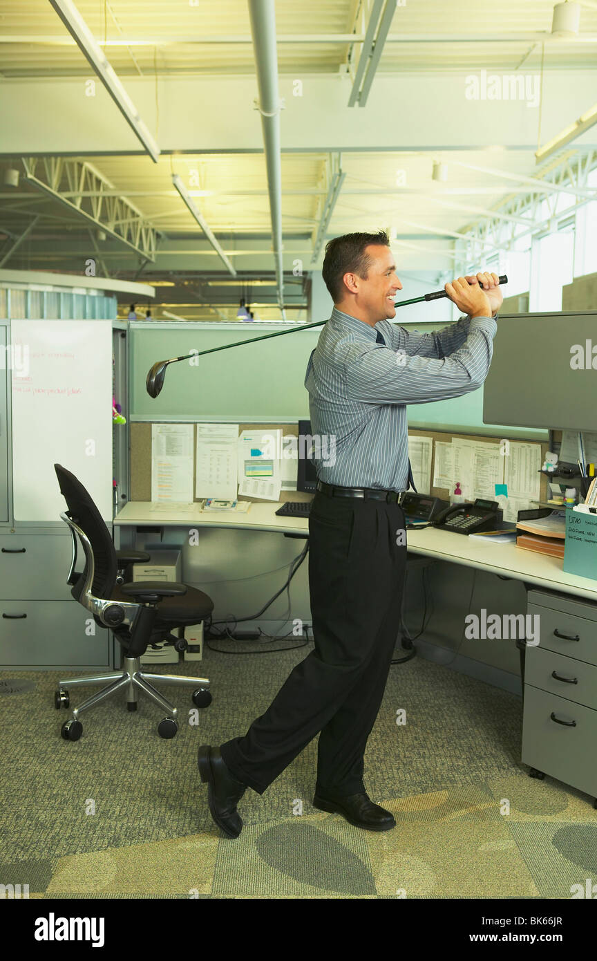 Businessman practicing golf in an office Stock Photo - Alamy
