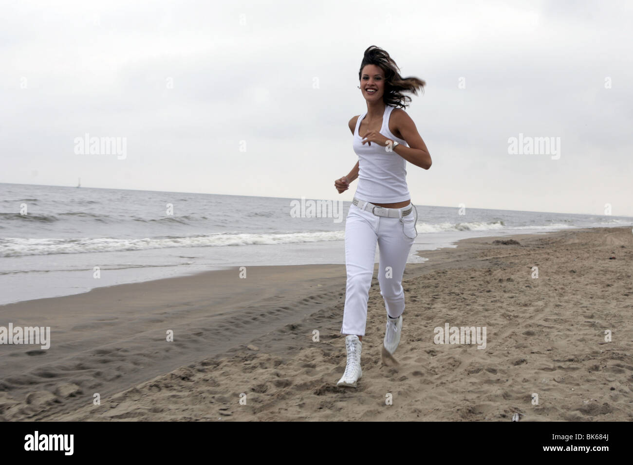 Young woman running at beach in summer Stock Photo - Alamy
