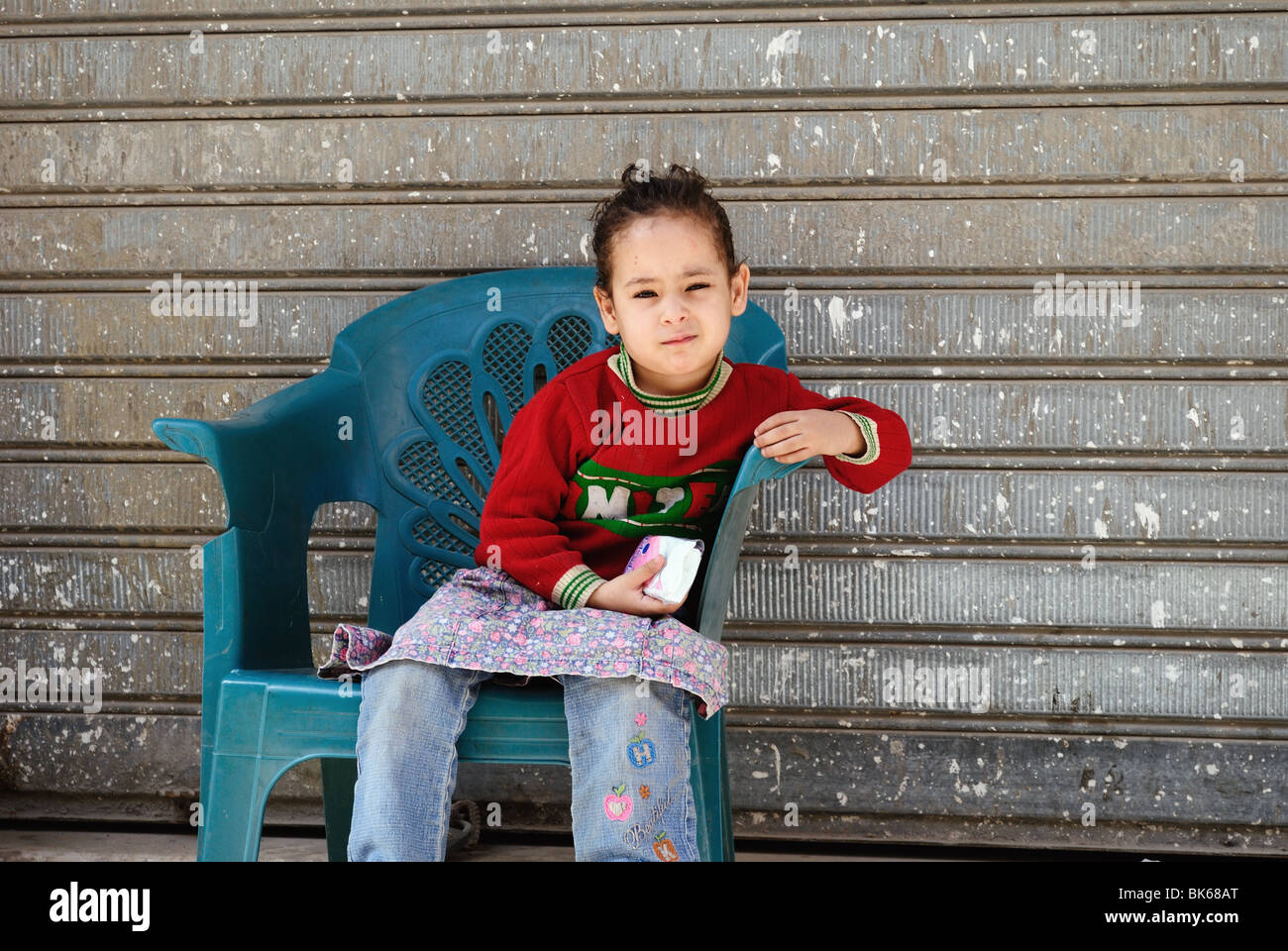 Little girl sitting in a chair, Cairo street, Egypt Stock Photo - Alamy