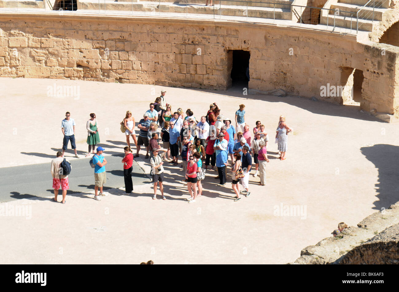 Tourists walk around the arena floor inside El Jem Roman Amphitheatre ...
