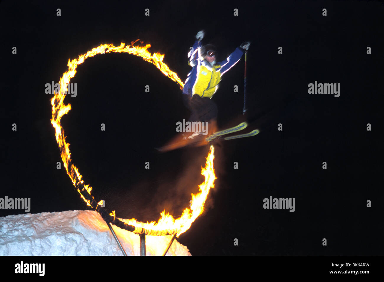 snow skier jumps through ring of fire at night Stock Photo - Alamy