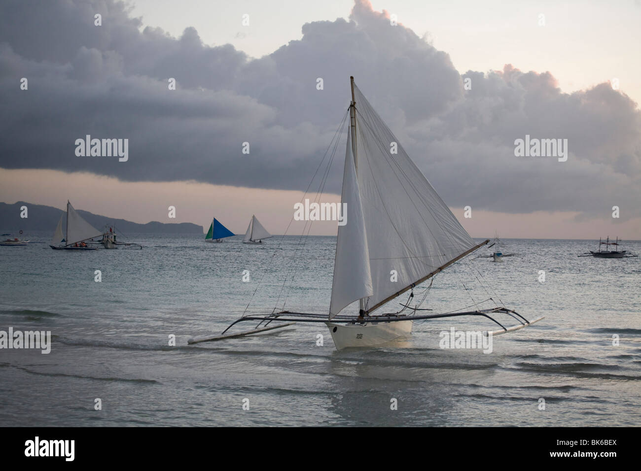 Single sailboat with clouds in background Stock Photo - Alamy