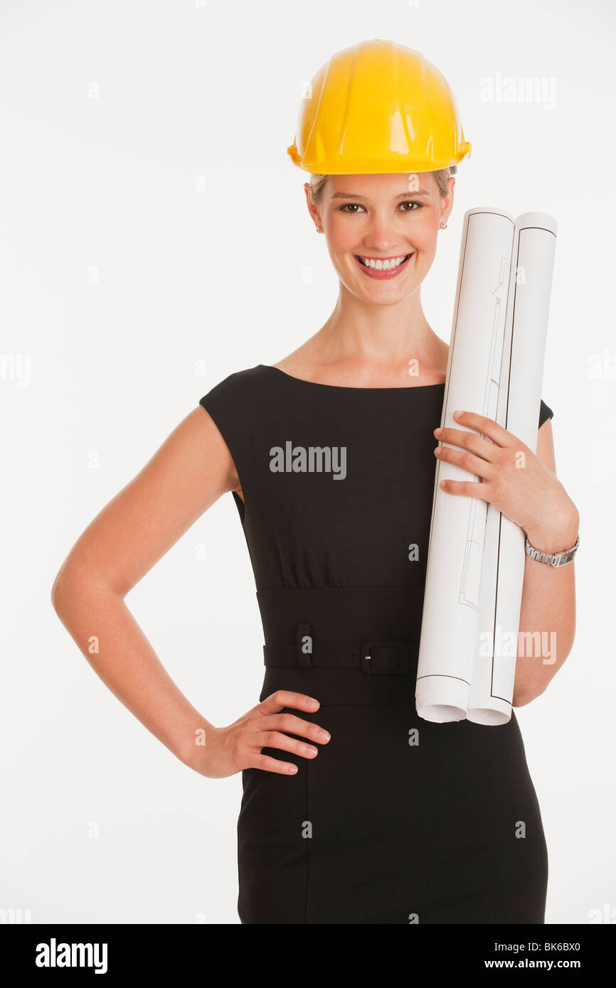 female architect with yellow hardhat on holding blueprints Stock Photo ...