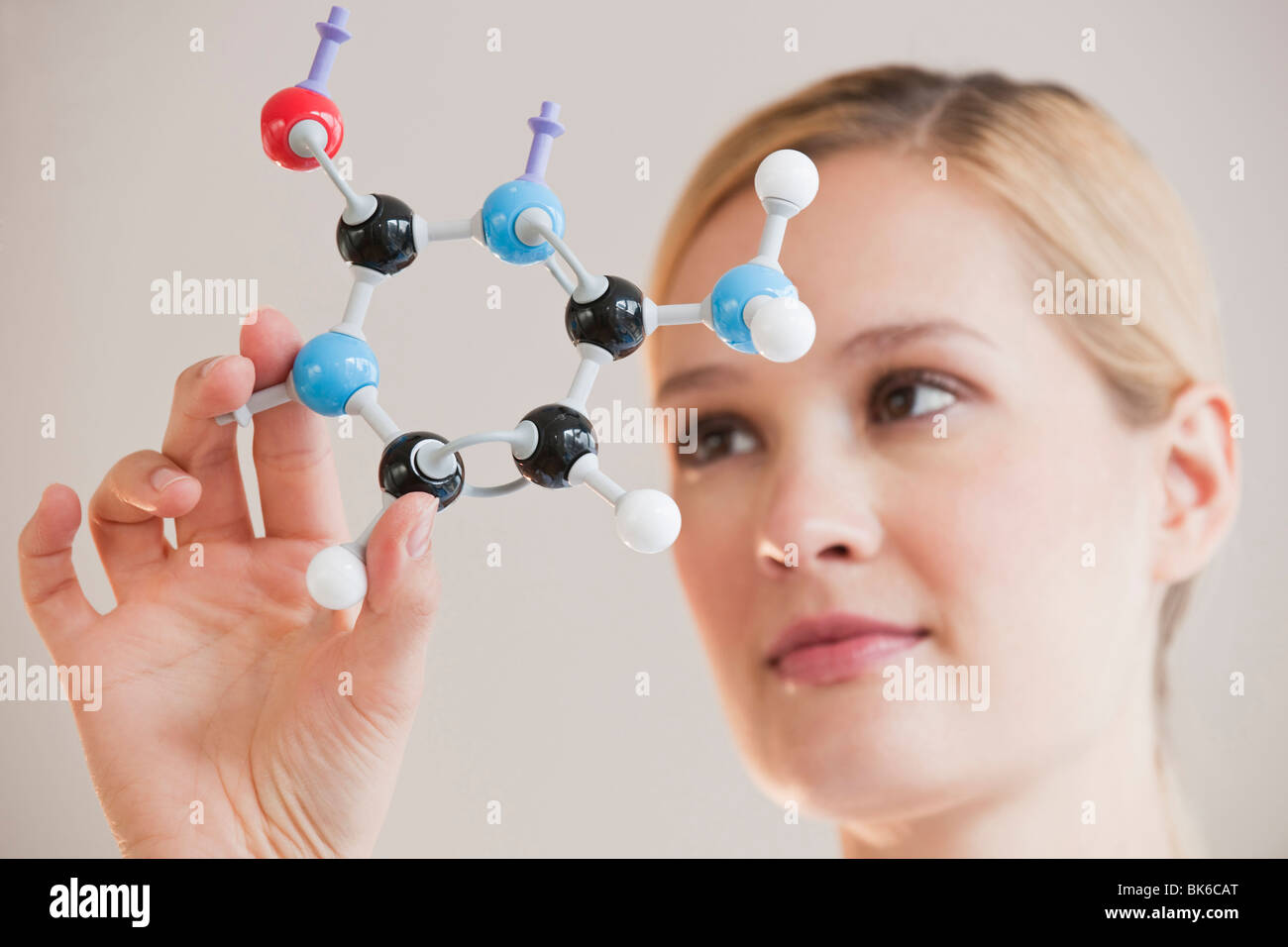 female chemist holding up molecules and looking at them Stock Photo - Alamy