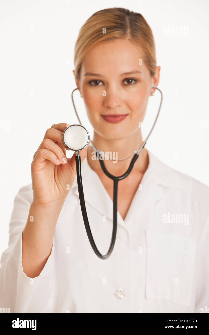female doctor holding stethcescope up to camera with white seamless ...