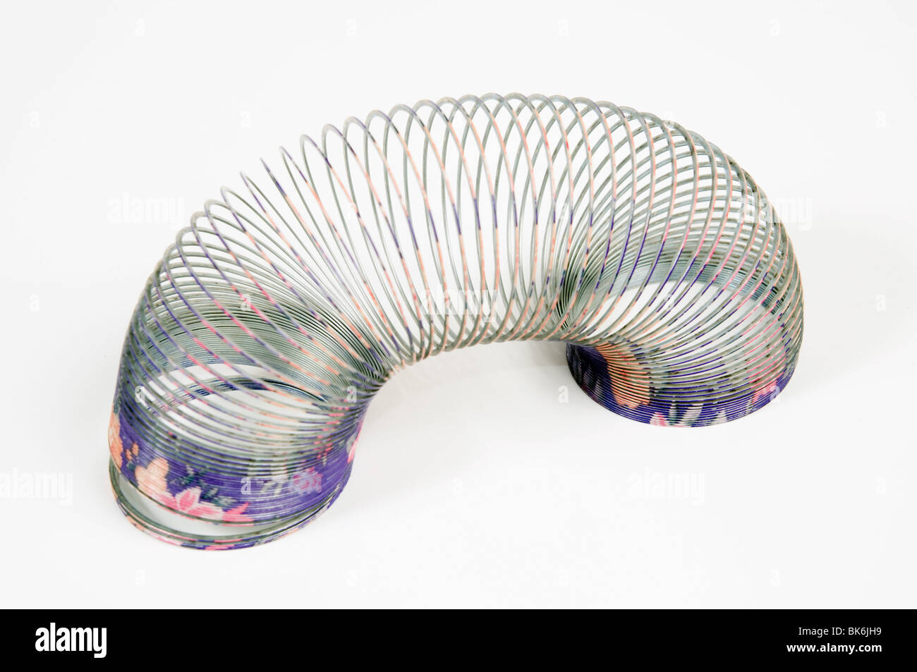 Metal Slinky toy on white background Stock Photo - Alamy