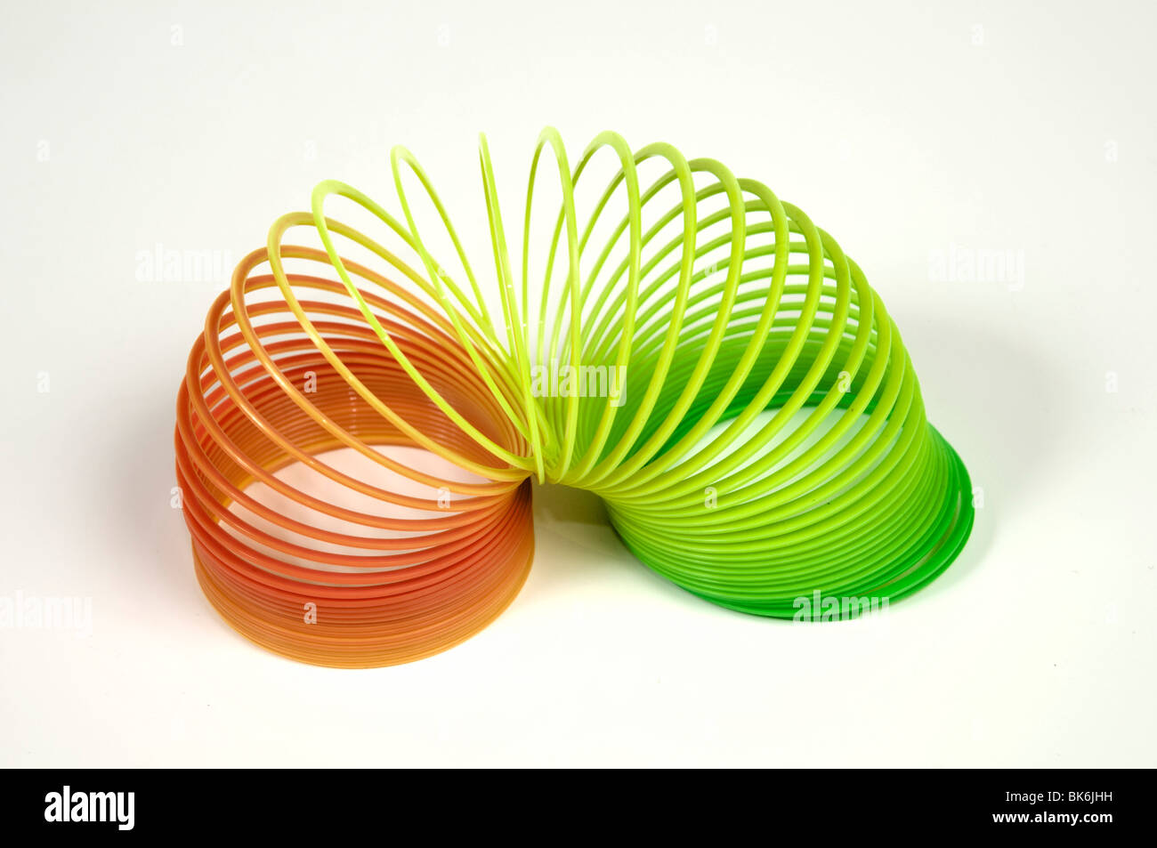 Colourful plastic Slinky toy on white background Stock Photo - Alamy