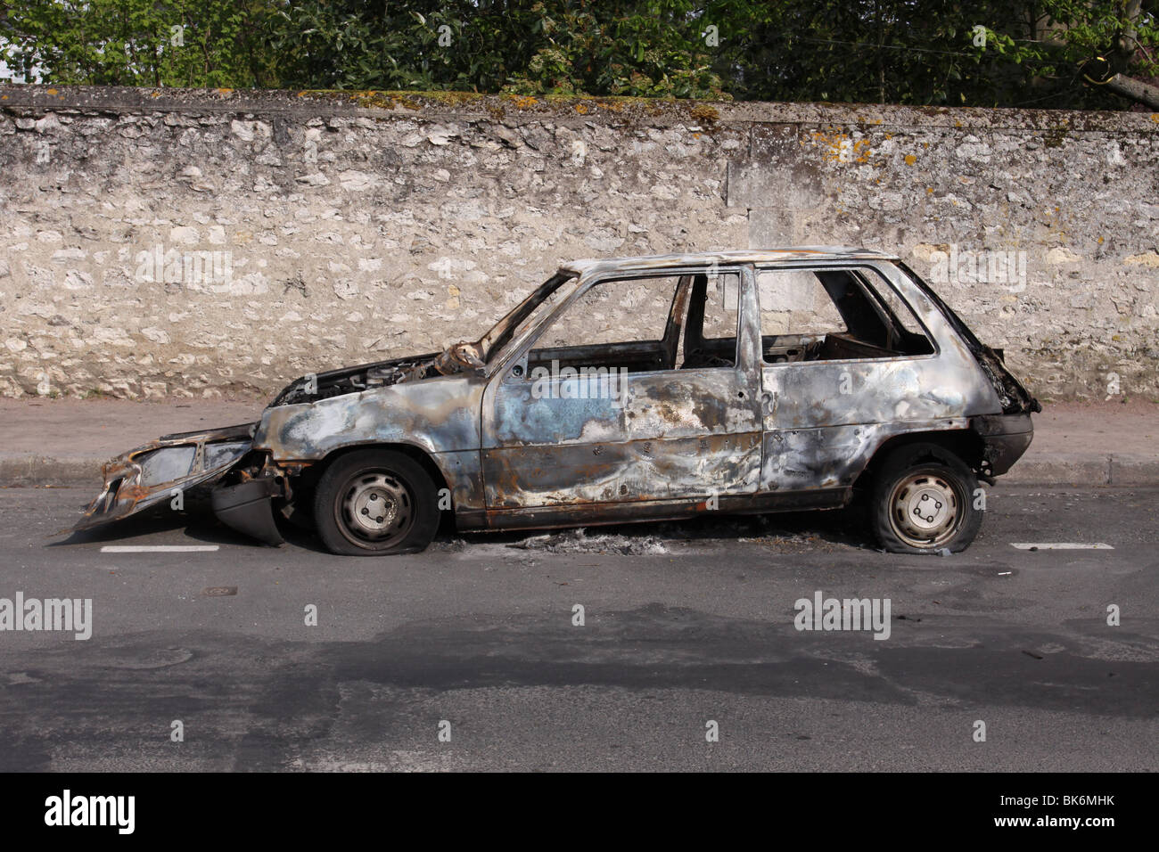 burnt out small car abandoned in road Stock Photo - Alamy