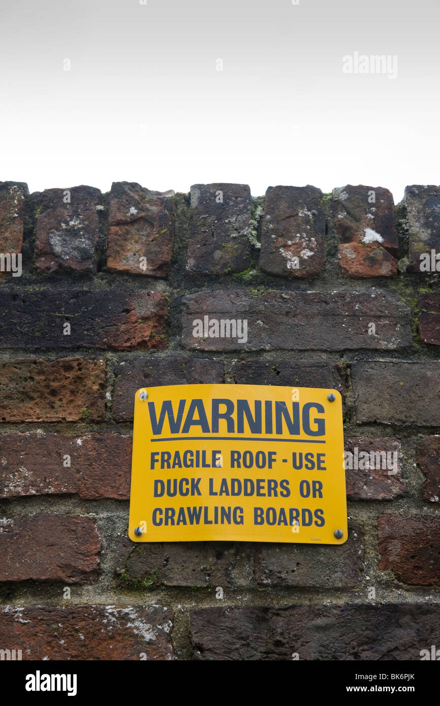 A warning sign on a wall Stock Photo - Alamy
