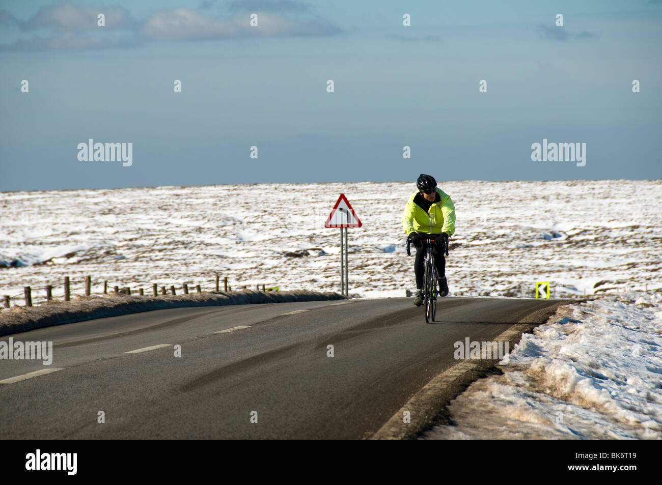 Cyclist on the A57 Snake Pass road in winter, near Glossop, Peak ...