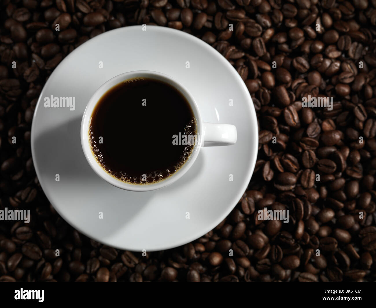 Cup of coffee standing on cofe beans High angle view Stock Photo - Alamy