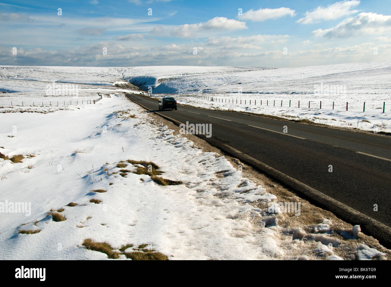 A car on the A57 Snake Pass road in winter, near Glossop, Peak District ...