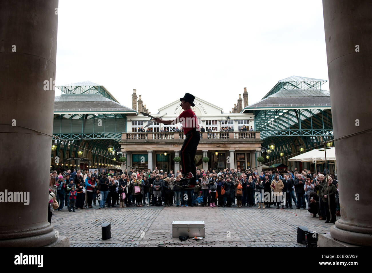 A knife juggler performs in the market of Covent Garden of London ...