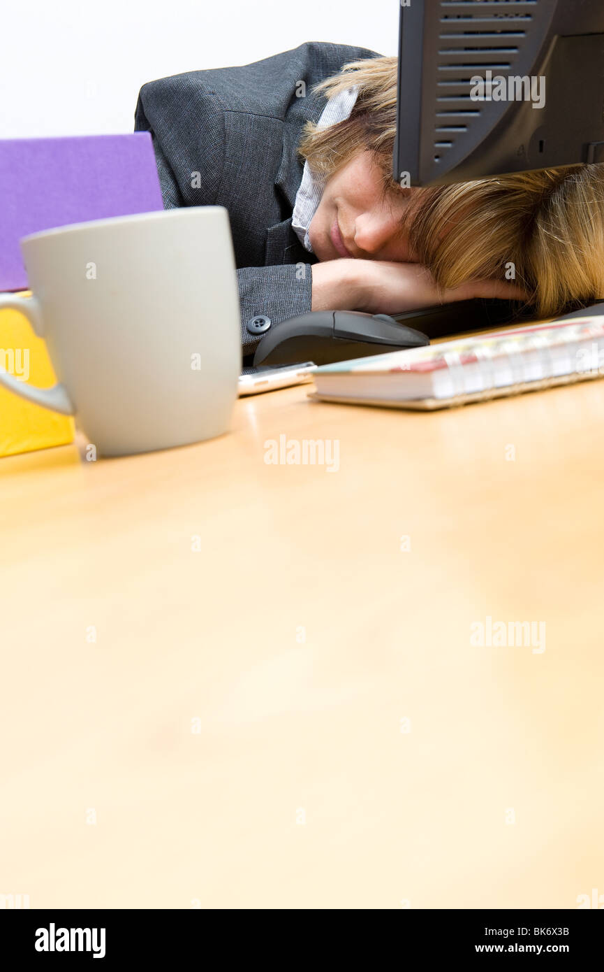 tired female office worker sleeping at desk Stock Photo - Alamy