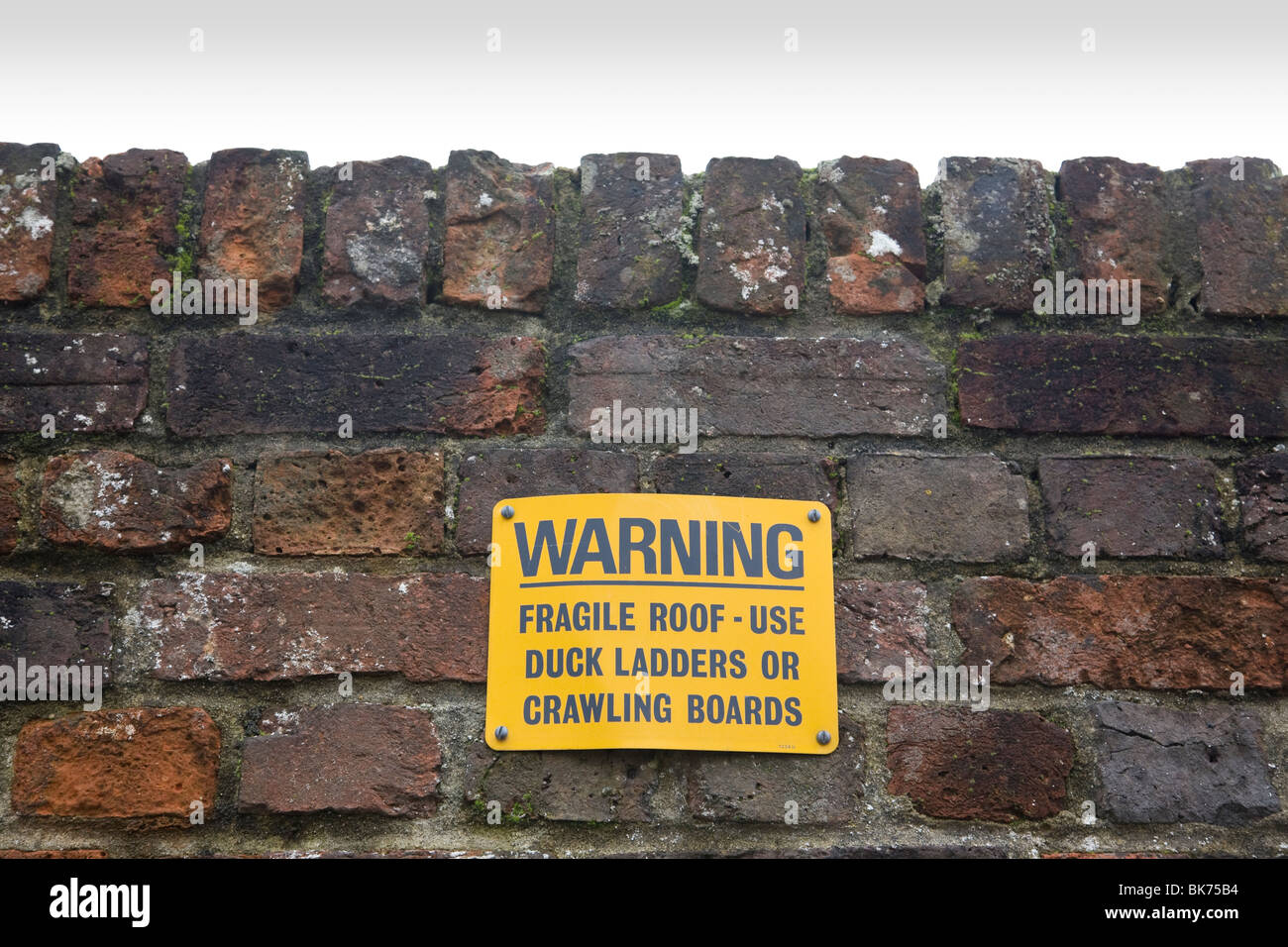 A warning sign on a wall Stock Photo - Alamy
