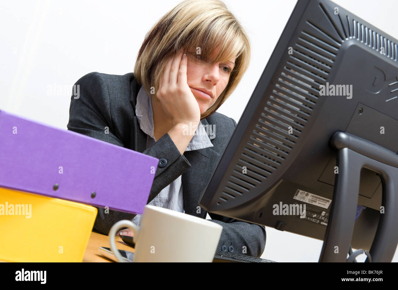 female office worker looking bored at computer screen Stock Photo - Alamy