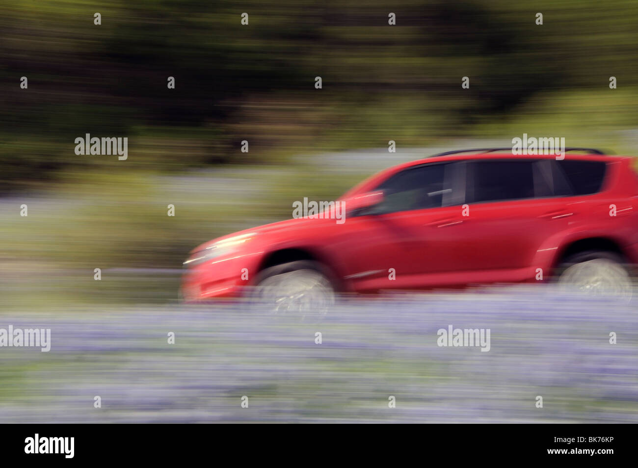 Vehicle driving past field of flowers Stock Photo - Alamy