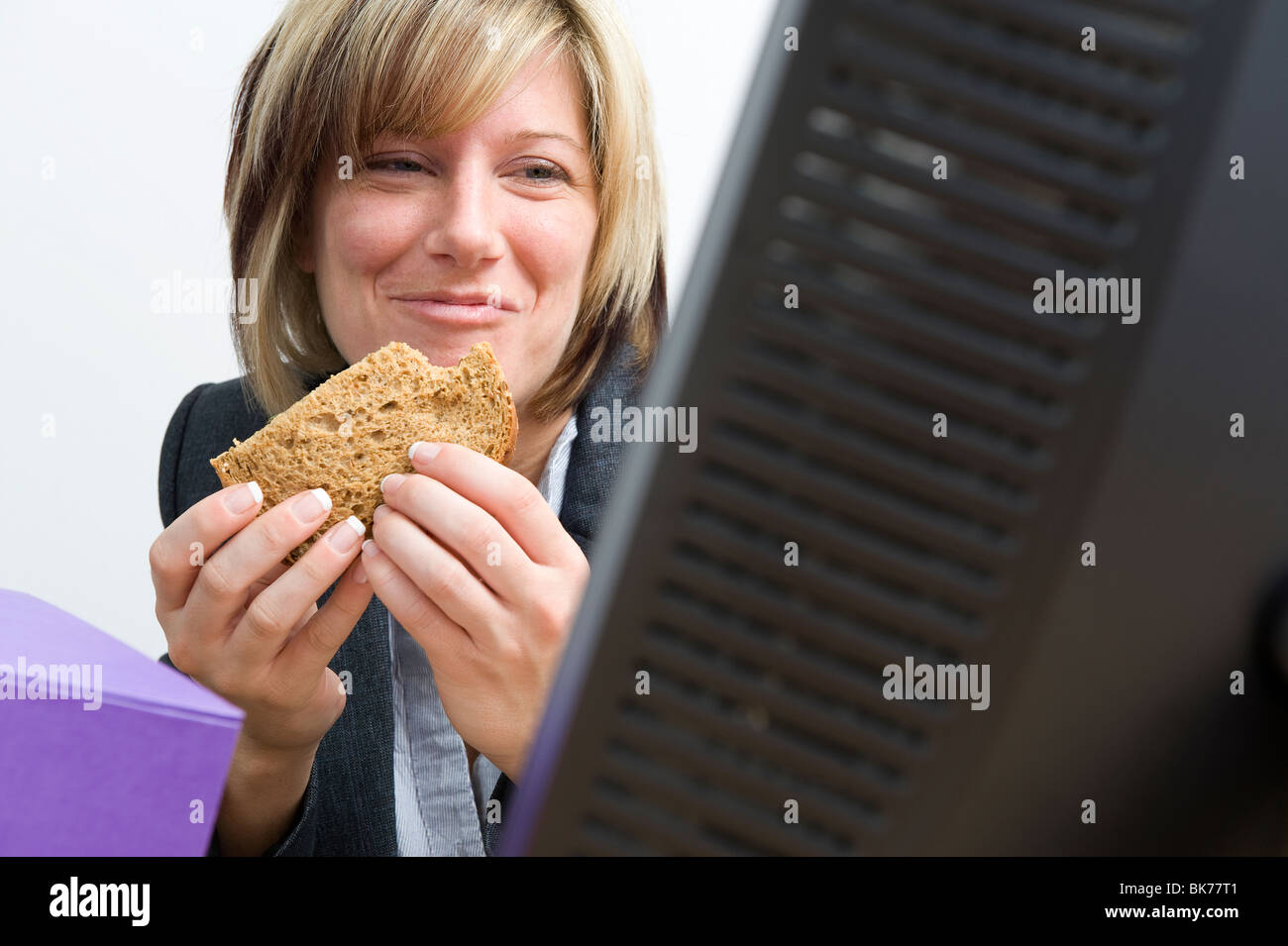 female office worker eating working lunch Stock Photo - Alamy