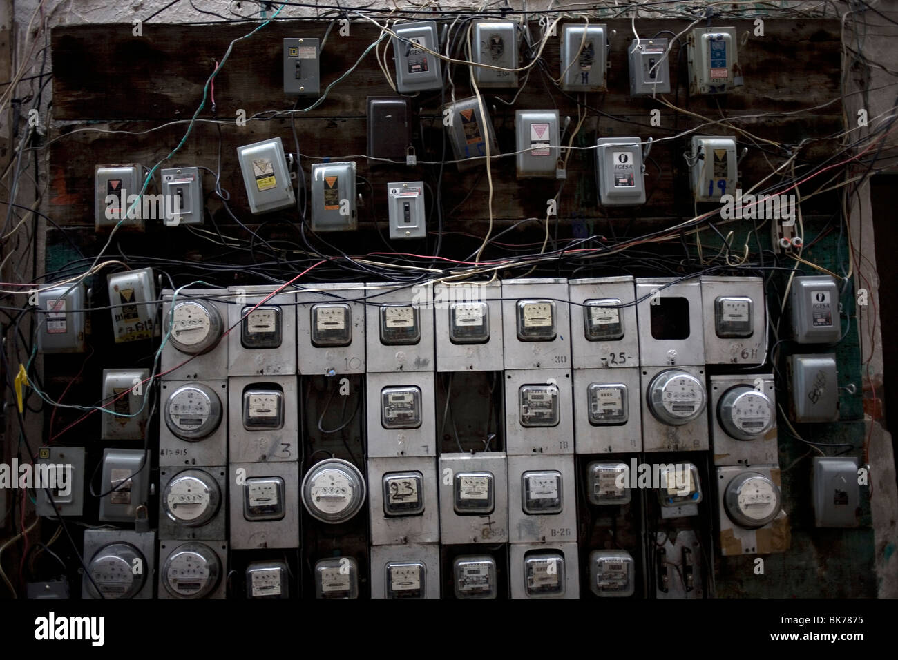 Electricity meters hang on a wall in an apartment building in Mexico ...