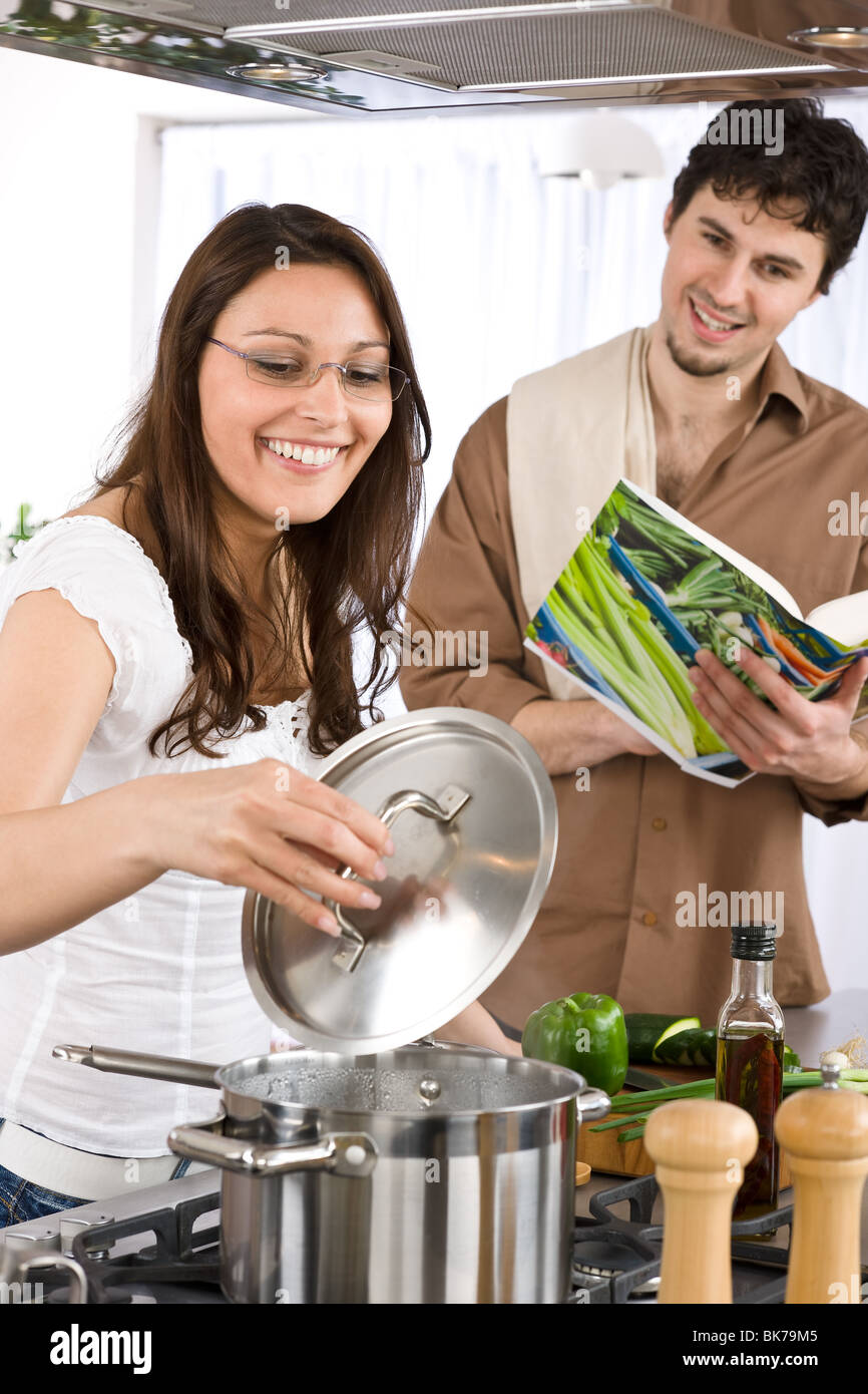Happy couple cook together in modern kitchen with cookbook Stock Photo ...
