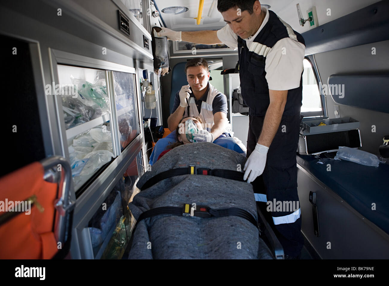 Ambulance staff and patient on stretcher Stock Photo - Alamy