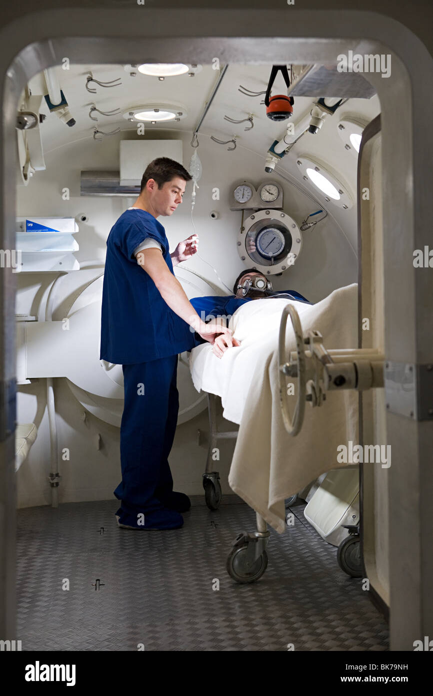 Nurse taking patient to hyperbaric chamber Stock Photo - Alamy