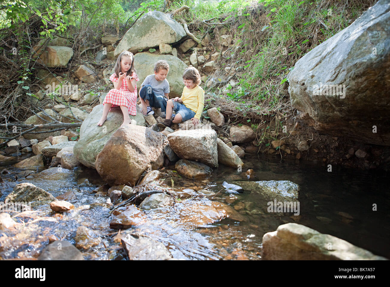 Children on rocks by river Stock Photo - Alamy