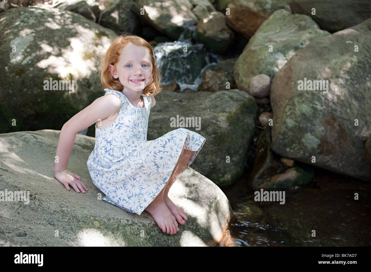 Girl on rocks by river Stock Photo - Alamy