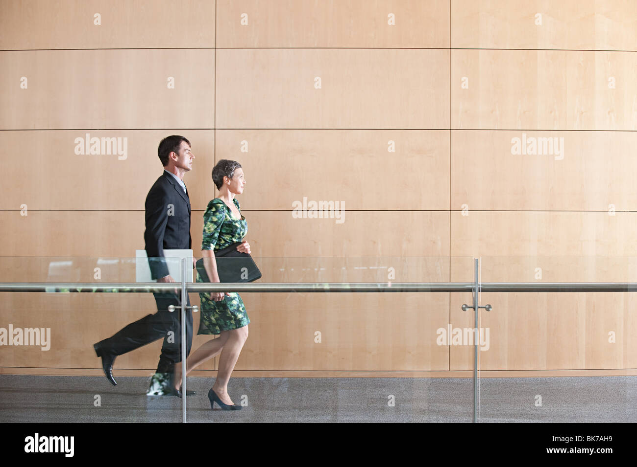 Businesspeople running through corridor Stock Photo - Alamy