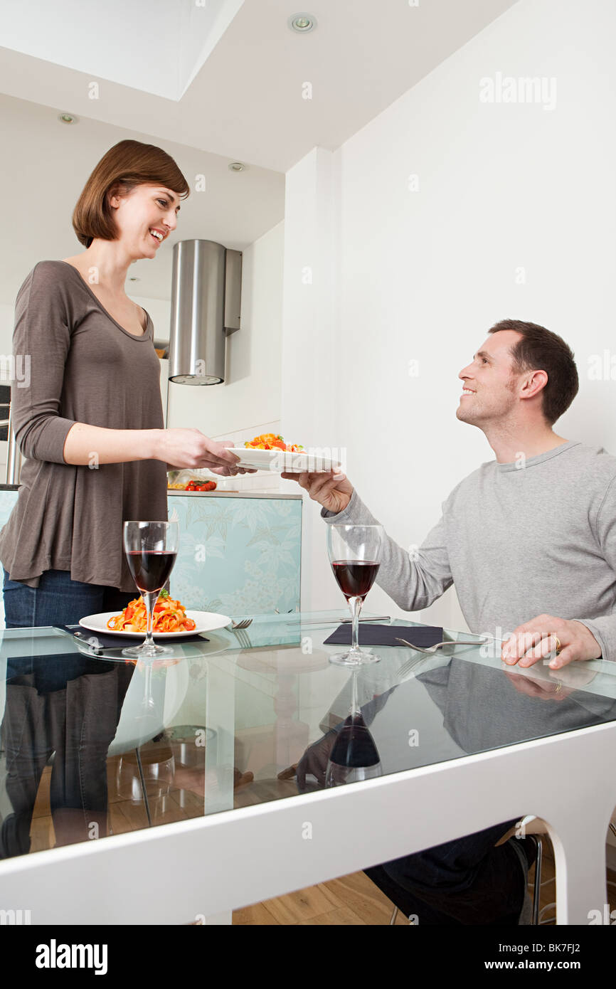 Woman passing plate to husband Stock Photo - Alamy
